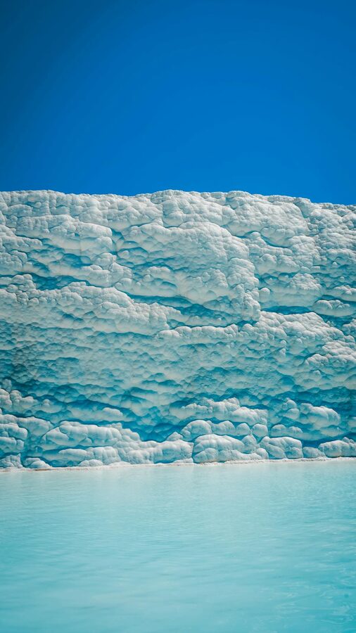 Wide view of Pamukkale white travertine terraces stretching across the hillside