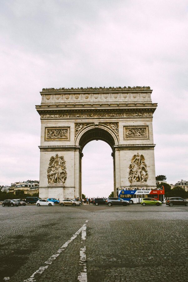 The Arc de Triomphe seen from the Champs-Élysées with traffic and trees