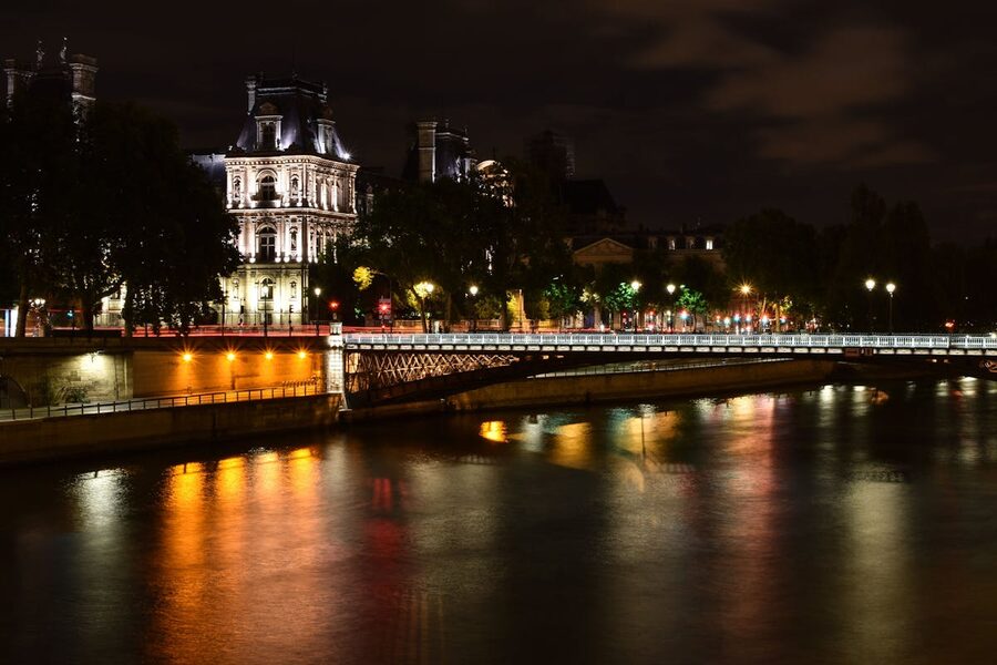 Paris at night with the Eiffel Tower illuminated and river reflections