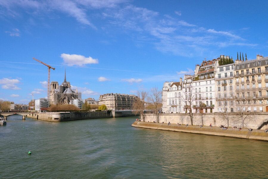 Seine River view with Notre-Dame Cathedral and Parisian buildings on a bright day
