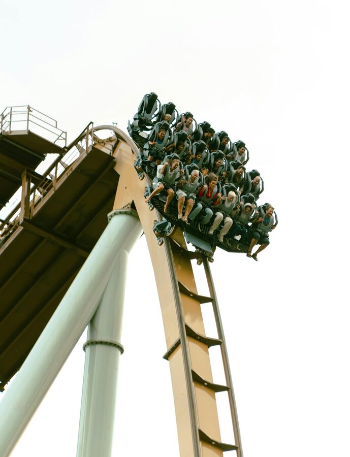 Riders on a roller coaster with excited expressions at a theme park