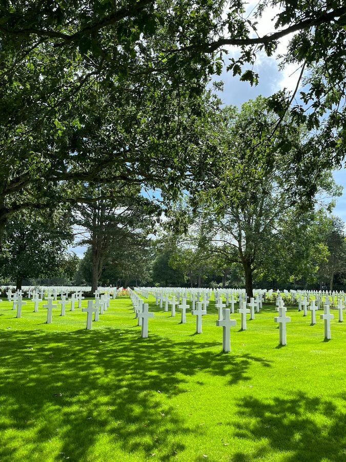 White crosses under trees at the Normandy American Cemetery