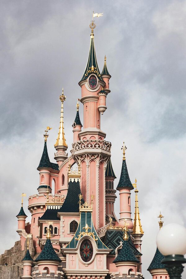 The Sleeping Beauty Castle at Disneyland Paris seen from a distance under a clear blue sky