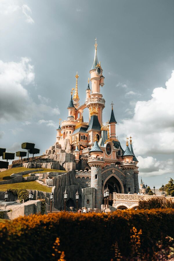 A dramatic view of a Disney castle under moody clouds