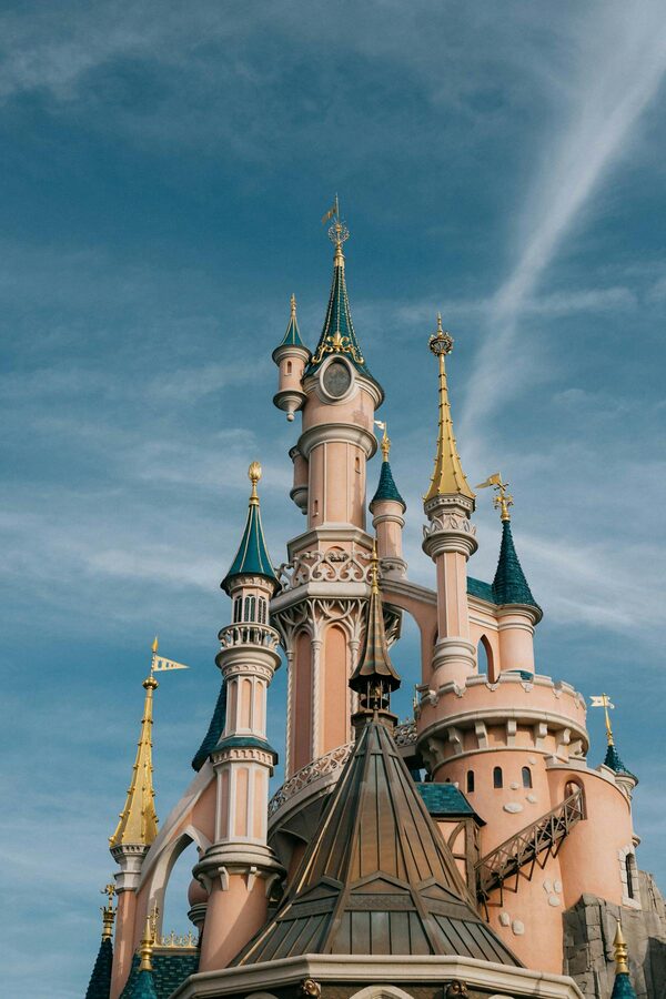 Close-up of Sleeping Beauty Castle tower spires at Disneyland Paris against blue sky