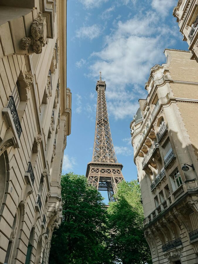 The Eiffel Tower framed by Parisian buildings and street architecture