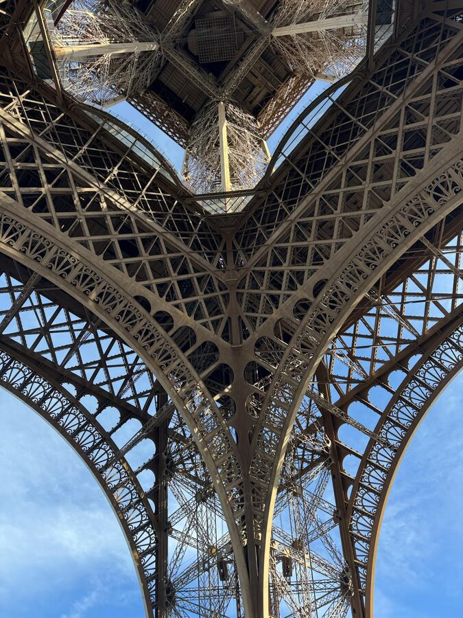 Eiffel Tower iron lattice seen from below against blue sky