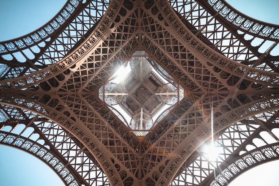 Sunlight bursting through the Eiffel Tower's iron structure