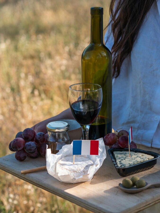 Outdoor picnic with French wine, cheese, and fresh grapes