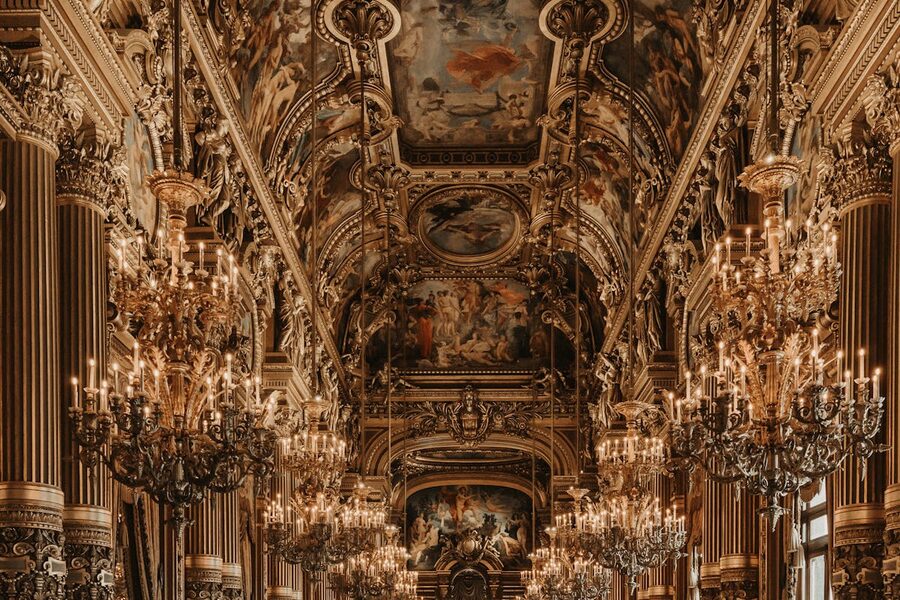 Lavish baroque interior of Palais Garnier with chandeliers and ornate ceiling paintings