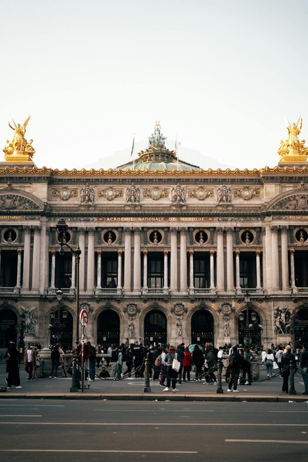 Facade of the Palais Garnier with crowds of visitors on the steps