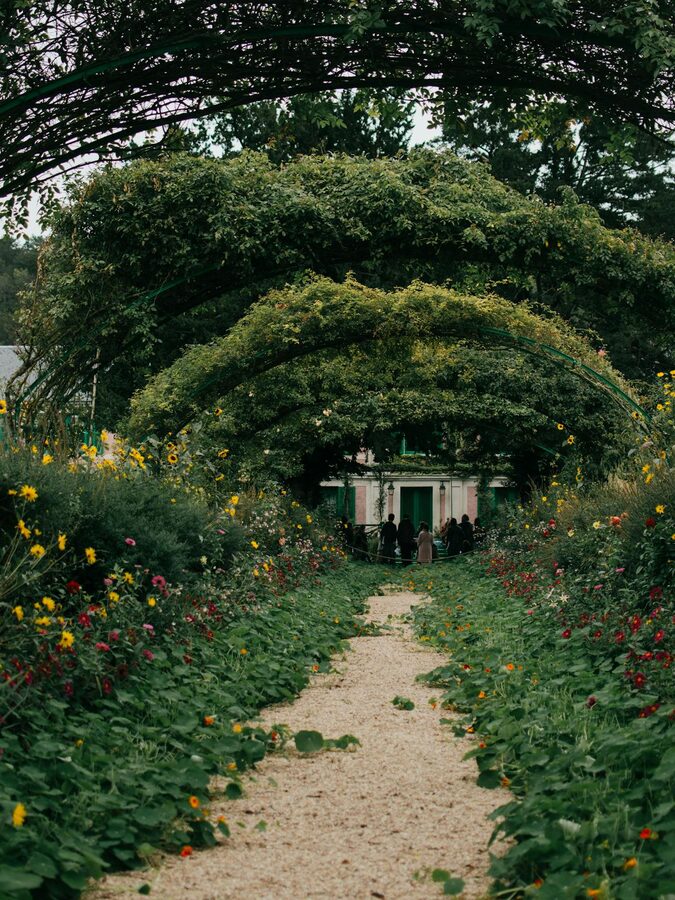 Floral archway leading to a garden path at Monet's house in Giverny