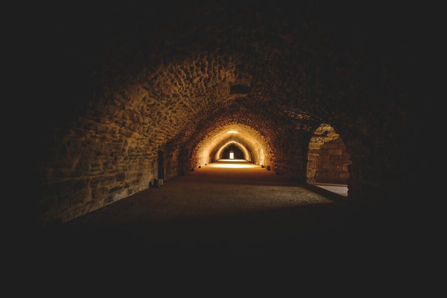 A gothic stone tunnel with warm lighting