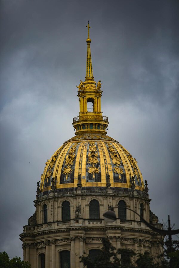 Golden dome of Les Invalides against a moody grey sky in Paris