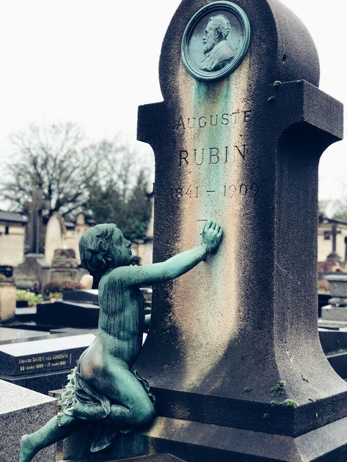 Cherub sculpture on a headstone at Père Lachaise
