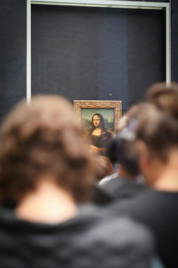 Tourists photographing the Mona Lisa at the Louvre Museum in Paris