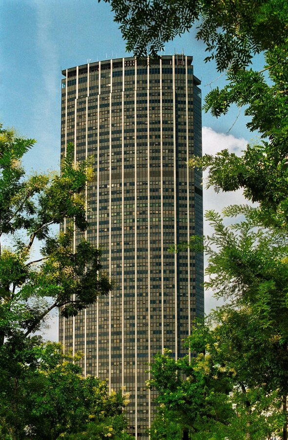Montparnasse Tower seen from below framed by surrounding Paris buildings