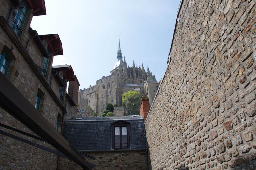 Stone walls of Mont Saint-Michel Abbey under a clear blue sky