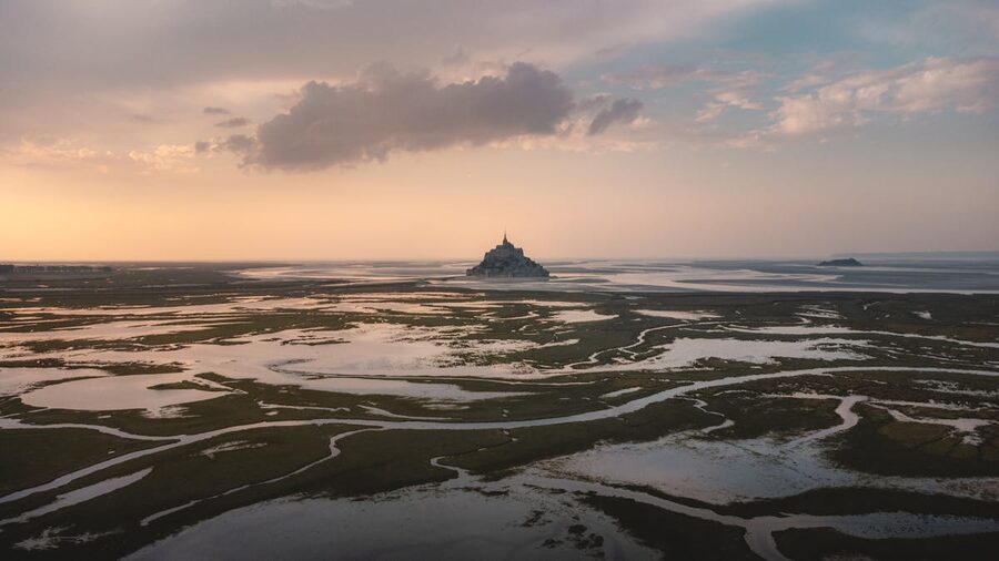 Aerial view of Mont Saint-Michel at low tide showing exposed sandy flats