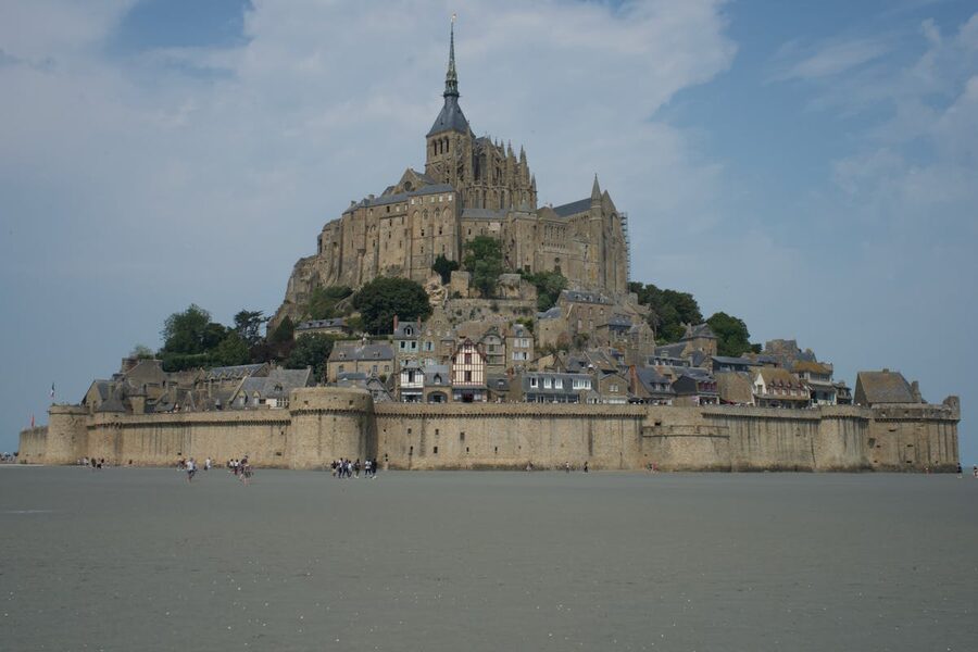 Mont Saint-Michel in the distance with green fields in the foreground