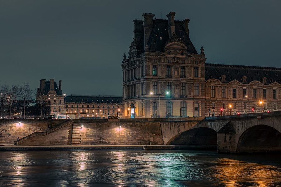 Illuminated Louvre Museum by the Seine at night