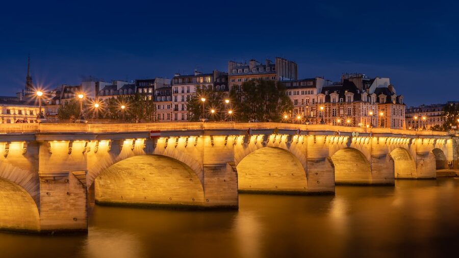 Pont Neuf bridge reflecting on the Seine at night