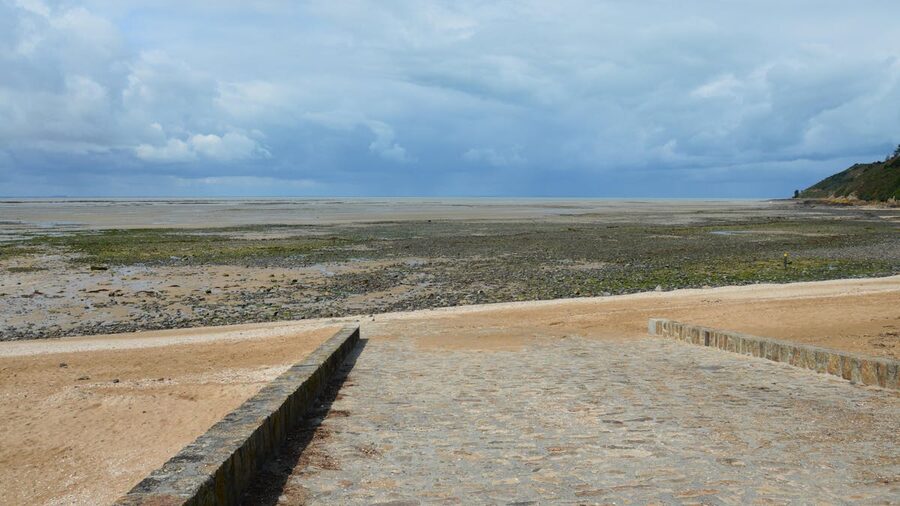 Tranquil Normandy beach at low tide with wide sand and calm water