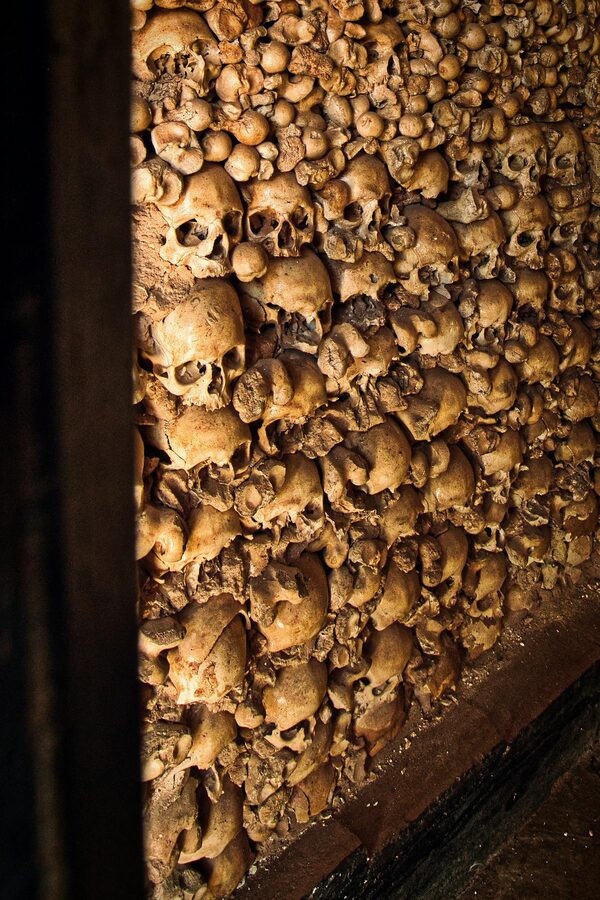 A wall of human skulls in an ossuary