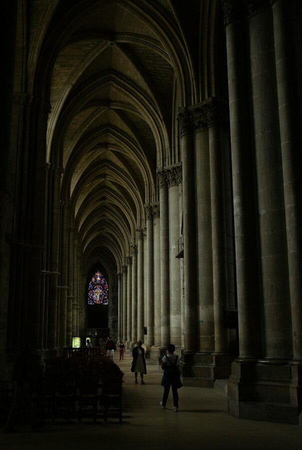 Gothic vaulted ceiling and stained glass windows inside Reims Cathedral
