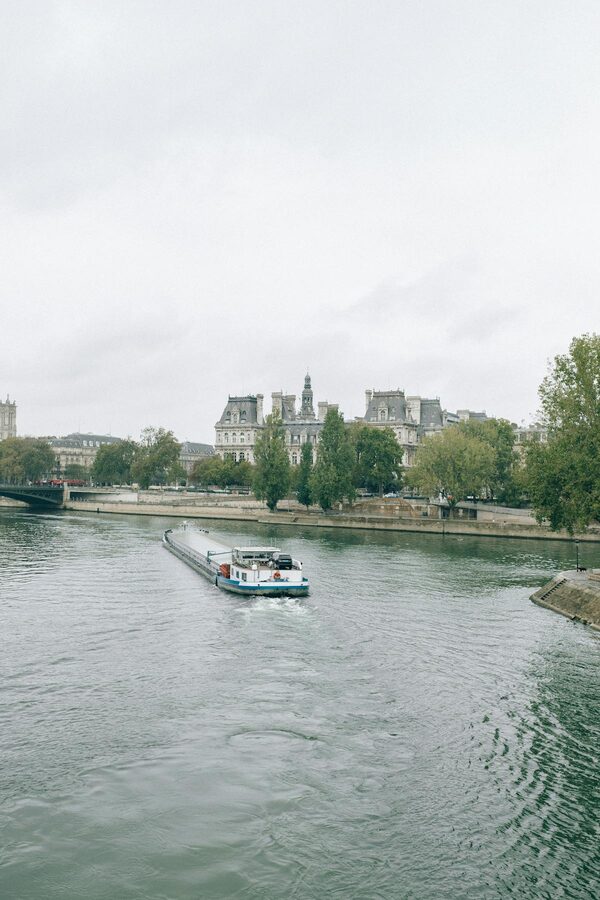 Seine River boat passing under a Paris bridge with classic architecture