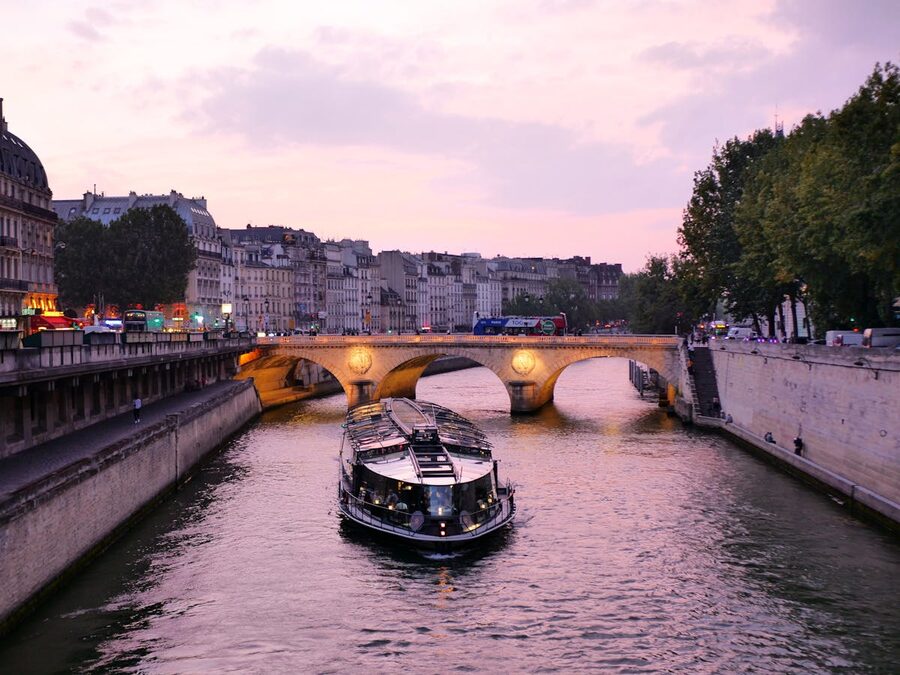 A boat on the Seine River at evening with historic Parisian buildings in the background