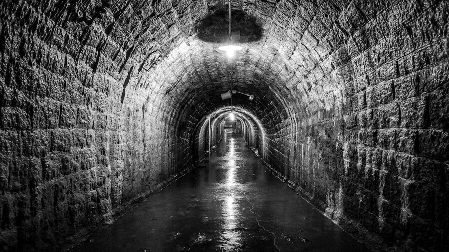 An atmospheric stone tunnel dimly lit