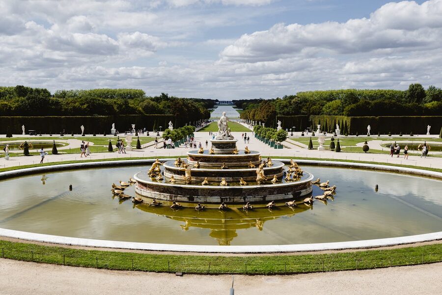 A view of a grand fountain in the Versailles gardens
