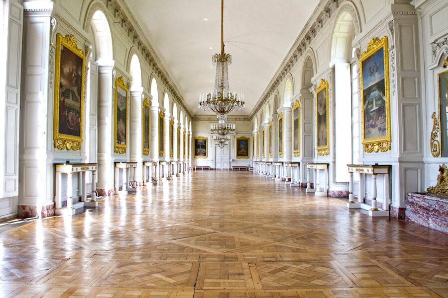 Ornate hallway inside the Grand Trianon at Versailles with chandeliers
