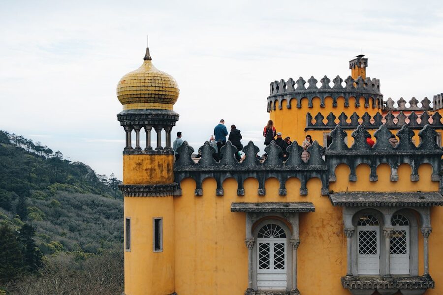 Visitors exploring the yellow towers and terraces of Pena Palace