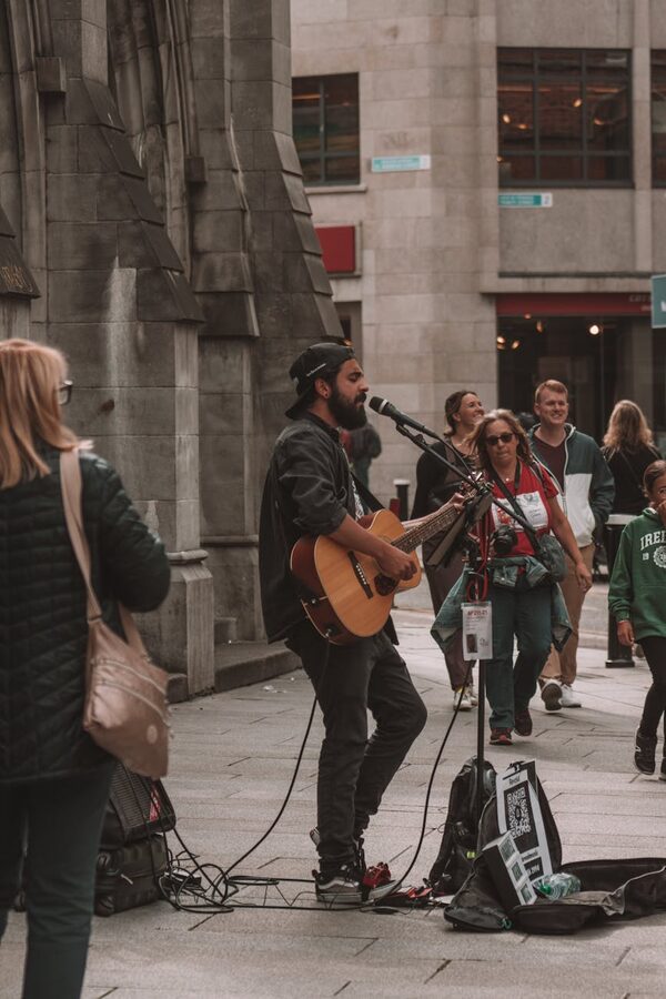 Man playing guitar singing on street