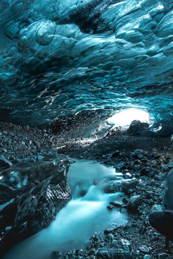 Frozen ice formations lining a narrow glacier tunnel