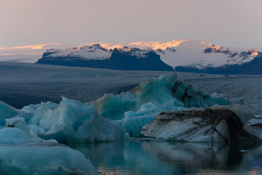 Close-up detail of a translucent iceberg in milky lagoon water