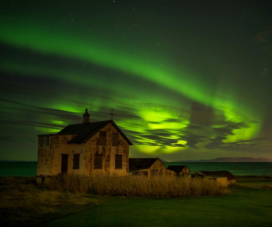 Northern lights over abandoned house on Keflavik coast Iceland