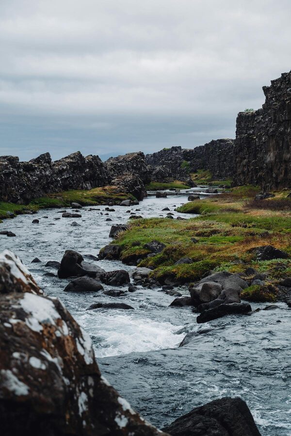 Thingvellir rushing river with mountains in background