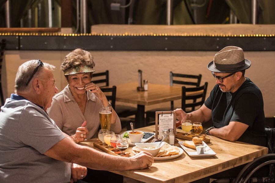 Group of friends enjoying craft beer and food at a bar