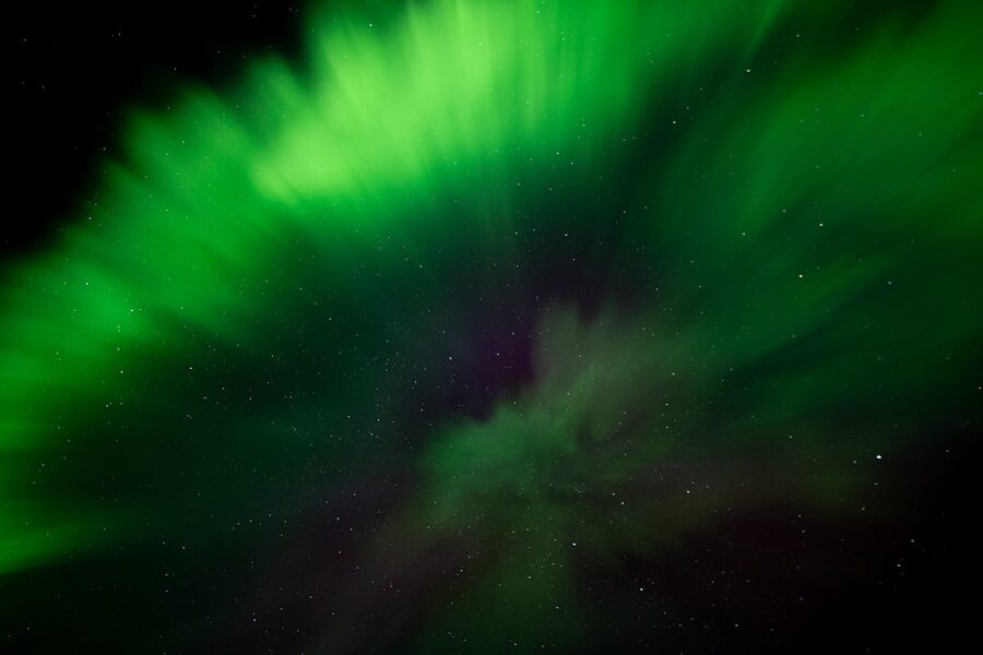 Green aurora borealis in starry night sky over Iceland