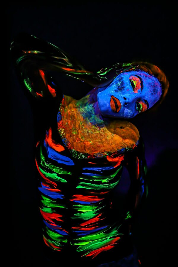 Body art glowing under ultraviolet black light