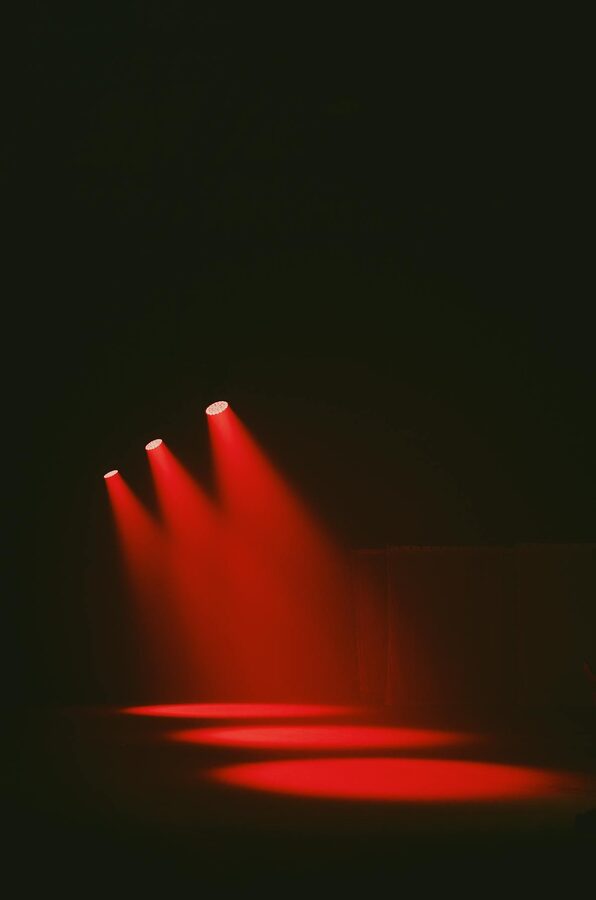 Red spotlights illuminating empty dark stage