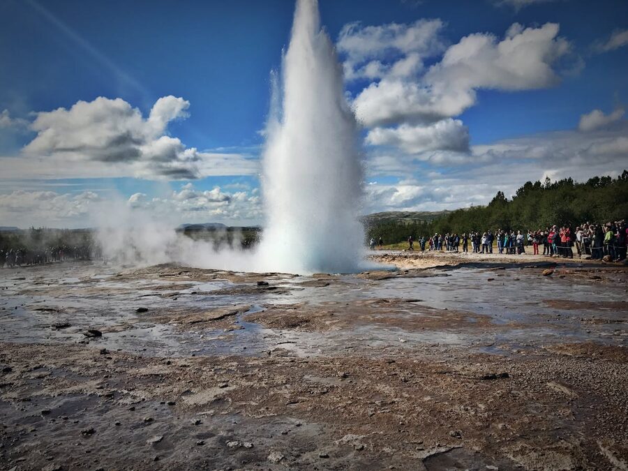 Tourists watching geyser eruption in Iceland