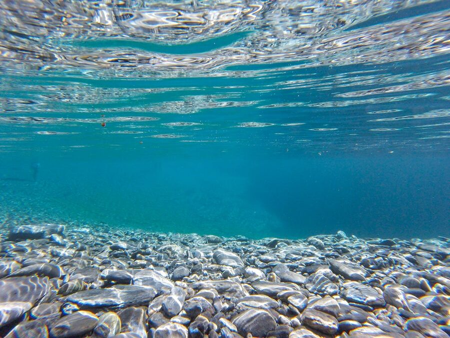 Crystal clear underwater view of rocky floor