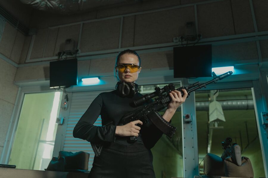 Woman confidently holding rifle at indoor shooting range