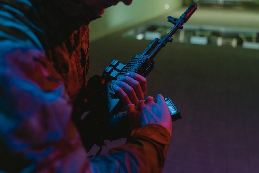 Person handling tactical rifle with colored accessories