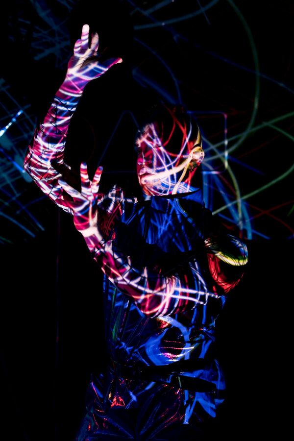 Neon light projections on person creating art