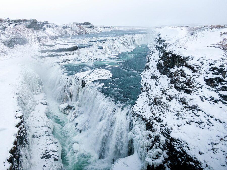 Frozen waterfall and snowy terrain in Iceland winter